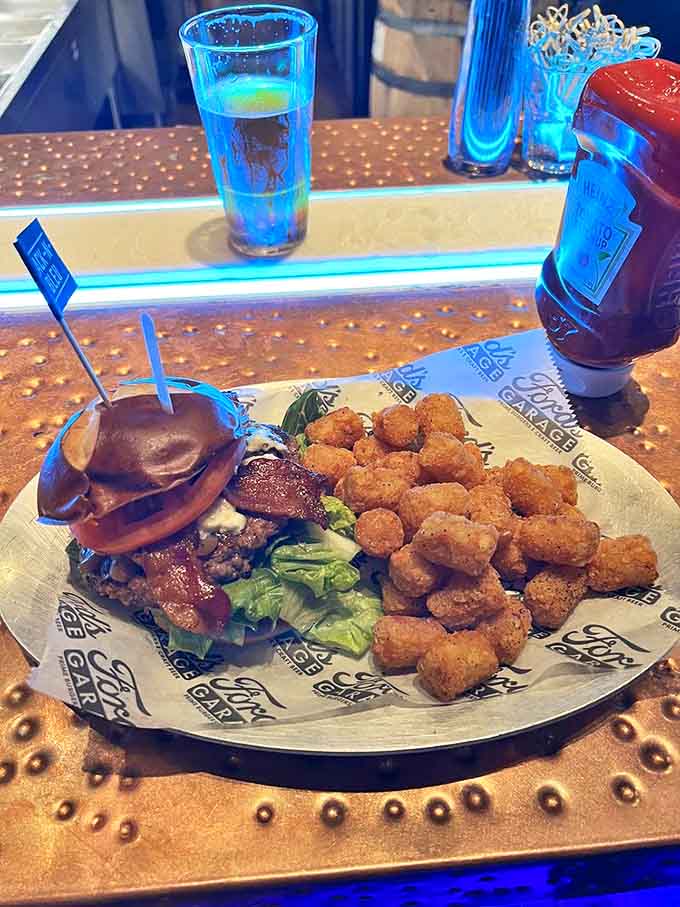 This isn't just any burger &ndash; it's architectural perfection with a side of golden tater tots that crunch like autumn leaves.