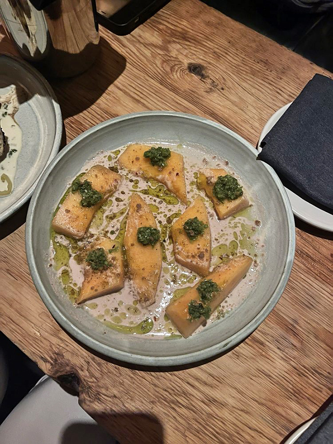 Delicate cantaloupe pieces bathed in a silky sauce with vibrant herb topping – proof that simple ingredients become extraordinary in skilled hands.