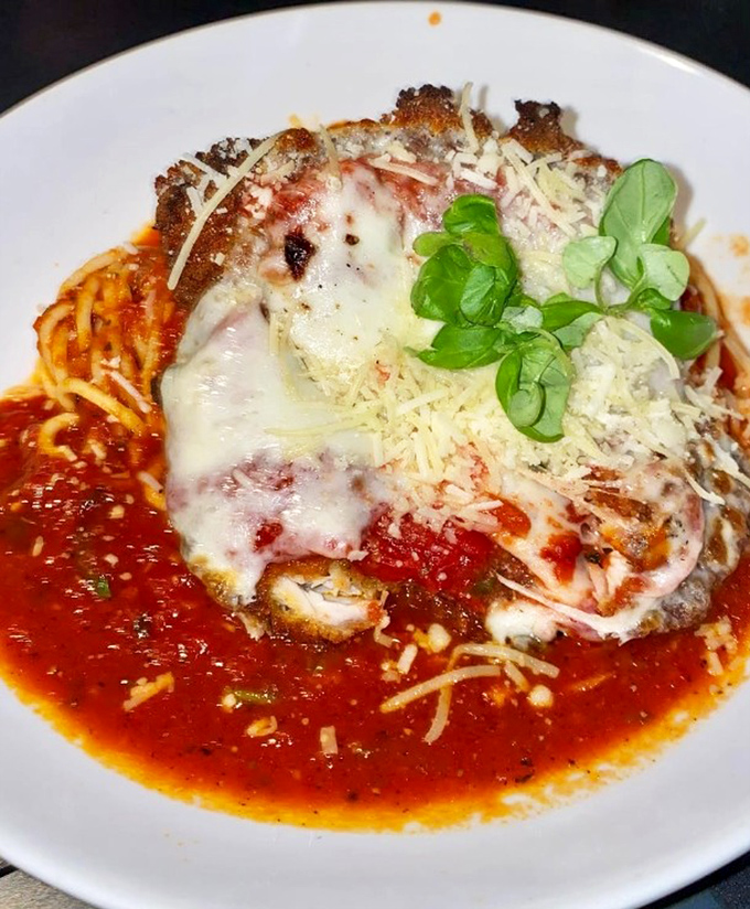 The legendary chicken parmesan &ndash; a masterpiece of crispy, juicy perfection topped with bubbling cheese and nestled in a pool of vibrant marinara sauce.