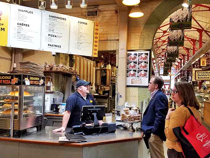 At the counter, culinary dreams become reality as staff prepare authentic Belgian treats with practiced precision.