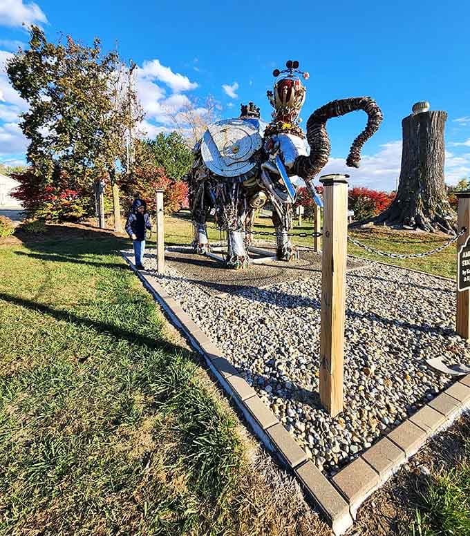 Sunshine illuminates every detail of this remarkable sculpture, from its chain-link trunk to its license plate accents, creating roadside art at its finest.