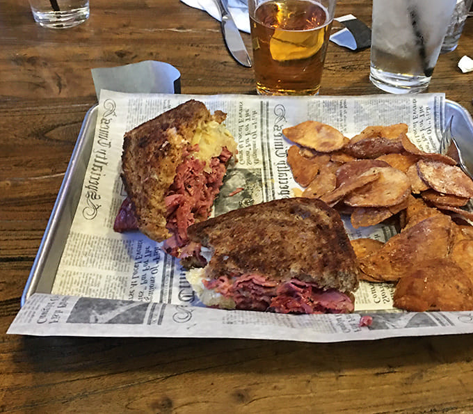 Behold the Reuben in all its glory, stuffed with corned beef and served with chips that deserve their own fan club.