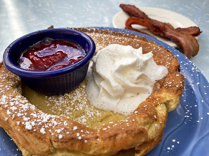 Dutch pancake perfection: crispy edges, tender center, and that dollop of whipped cream slowly melting into breakfast nirvana.