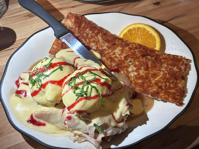 Eggs Benedict reimagined &ndash; perfectly poached eggs and pulled pork atop crispy hashbrowns with hollandaise cascading down like liquid gold.