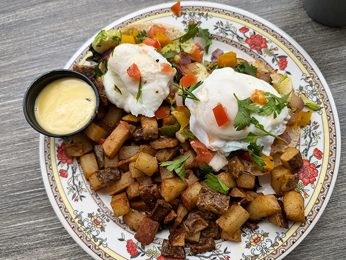 Two perfectly poached eggs crown a mountain of seasoned home fries &ndash; breakfast architecture at its finest, with a side of hollandaise for good measure.