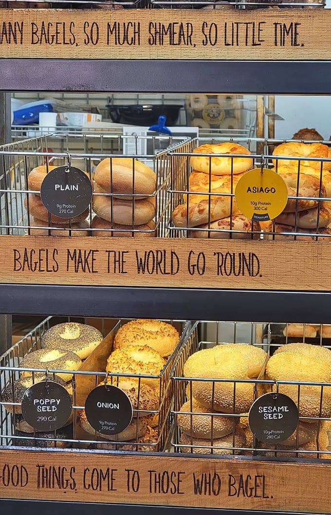 "So many bagels, so much shmear, so little time" &ndash; wooden shelves cradle golden rings of joy, each promising a different flavor adventure.