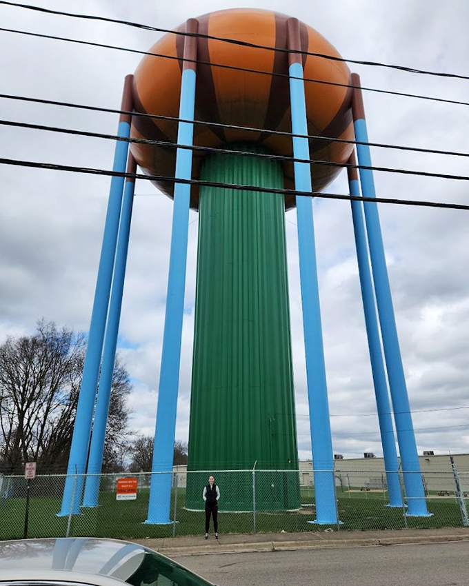 The tower's vibrant orange dome contrasts dramatically with surrounding residential neighborhoods, turning ordinary streets into surreal landscapes.