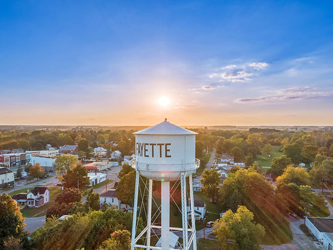 The iconic water tower proudly announces "FAYETTE" against the sunset sky – a beacon welcoming travelers home from miles around.