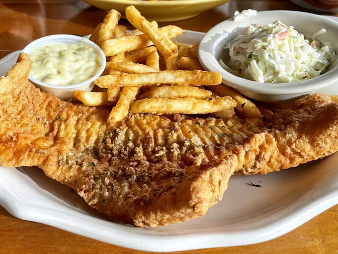 Golden perfection on a plate &ndash; this fish and chips masterpiece features flaky white fish in crispy batter alongside hand-cut fries and creamy house-made coleslaw.