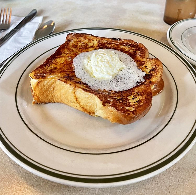 Not just French toast – a masterpiece of custard-soaked challah with a perfectly centered egg that makes ordinary breakfast seem like a tragic missed opportunity.
