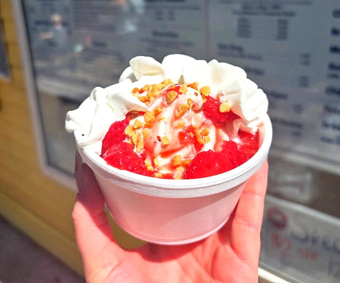 Strawberry sundae delight: Fresh strawberries cascade over vanilla soft serve, topped with whipped cream and nuts &ndash; summer in a cup.