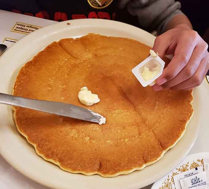 That pancake's bigger than your head and fluffier than a cloud, ready to make your morning infinitely better with every buttery bite.