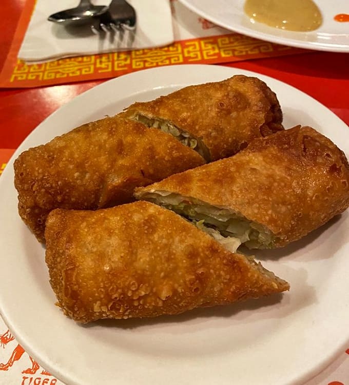 Golden, crispy egg rolls emerge from the kitchen like edible treasure, their perfectly fried wrappers promising the savory goodness waiting inside.