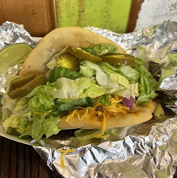 Behold the frybread taco in all its glory, piled high with fresh toppings that somehow stay perfectly contained in that pillowy base.