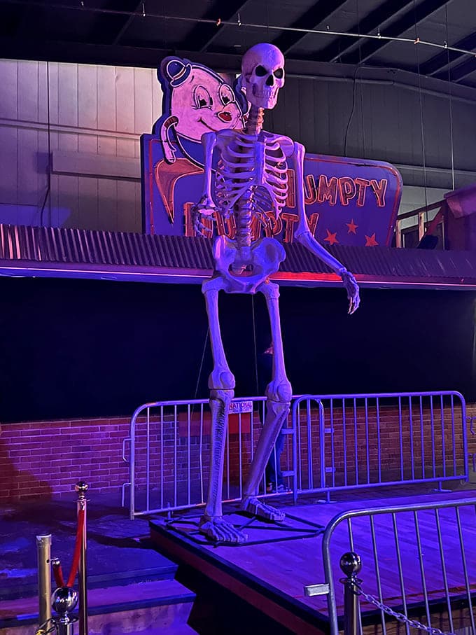 A towering skeleton stands guard near the Humpty Dumpty sign, combining childhood imagery with mortality in a way that's both playful and deeply disturbing.