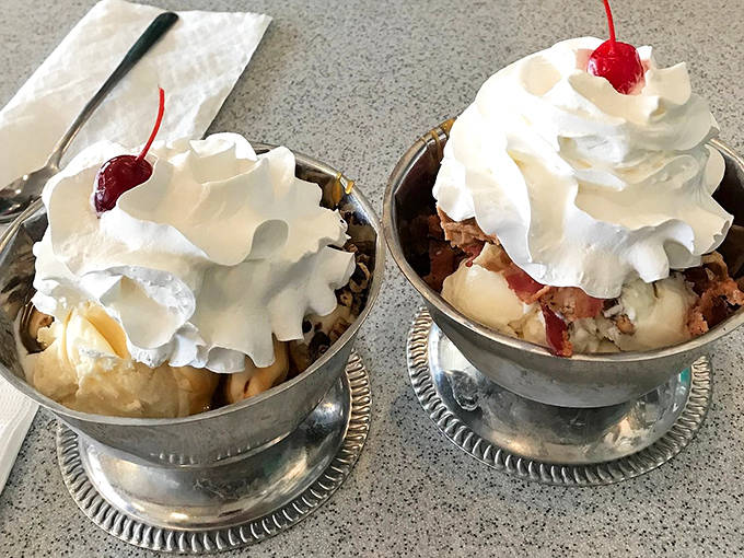 Silver dishes cradle mountains of ice cream topped with clouds of whipped cream – these sundaes aren't just desserts, they're edible art.