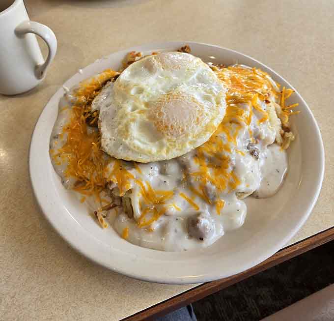 Behold the breakfast masterpiece: hash browns buried under gravy, cheese, and a perfectly cooked egg that's ready to break and run.