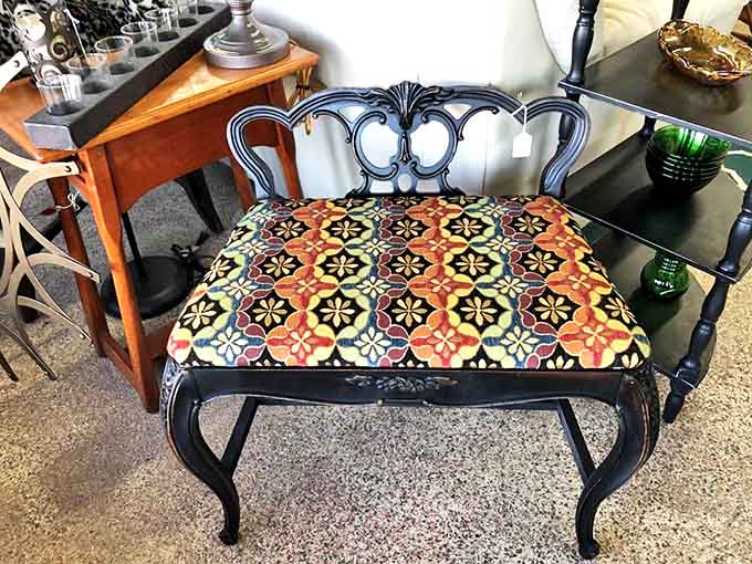 That ornate black bench with geometric upholstery proves that sometimes the best design happens when different eras decide to become friends.