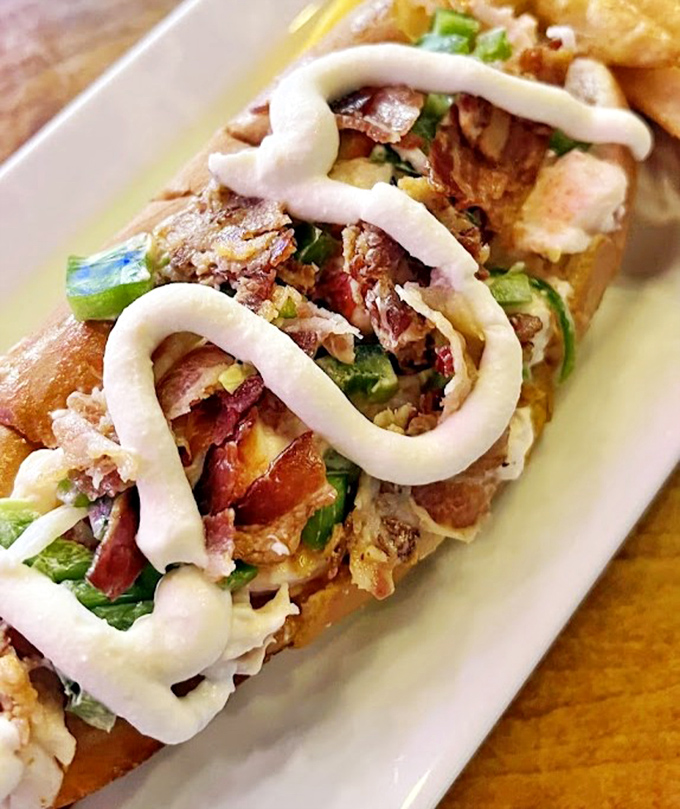 This isn't just a sandwich; it's a masterclass in seafood architecture&mdash;tender lobster meat artfully arranged with a zigzag of creamy sauce.