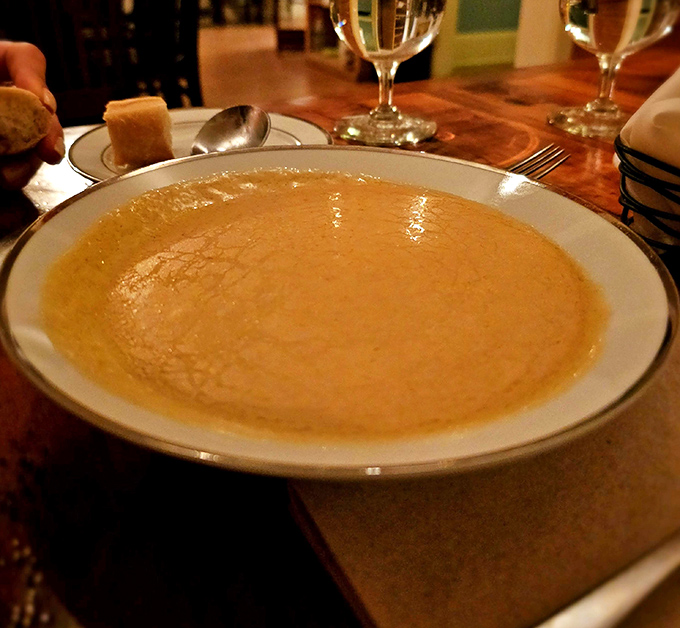 Liquid gold in a bowl &ndash; the legendary lobster bisque arrives with a velvety surface that hints at the rich, complex flavors waiting below.