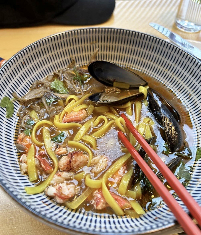 Maine meets Thailand in this cross-cultural masterpiece &ndash; sweet lobster meat swimming alongside plump mussels in a broth that dances between sour and spicy.