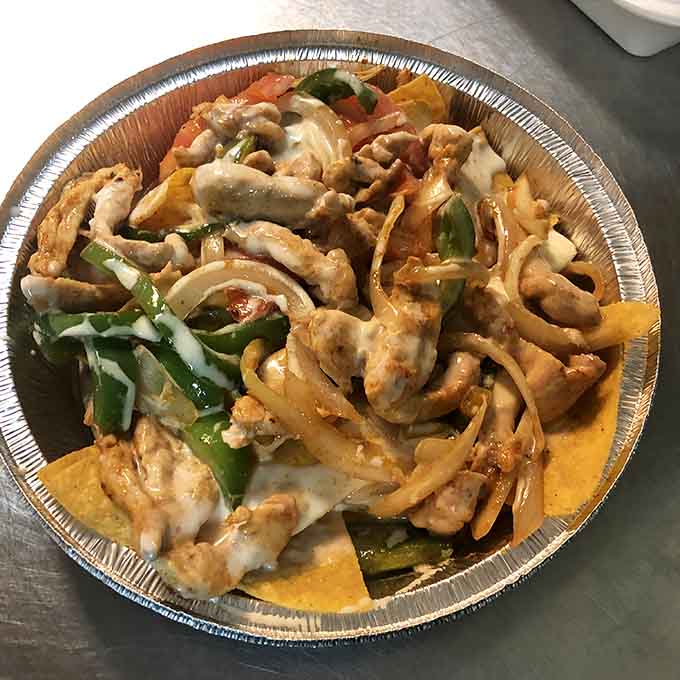 Fajita nachos create the kind of beautiful chaos that makes sharing both mandatory and deeply regrettable when you realize how good they taste.