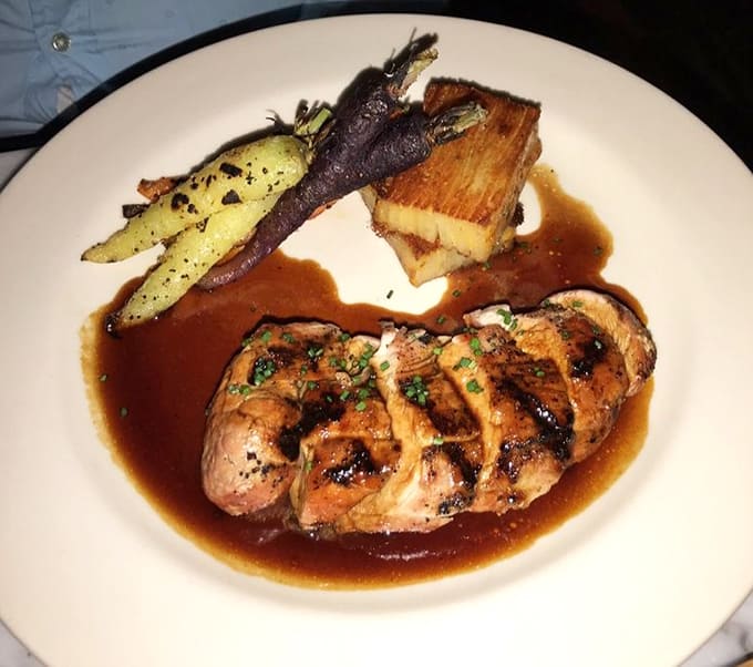 This pork tenderloin looks like it stepped off a cooking show set, perfectly plated with vegetables that actually look appetizing.