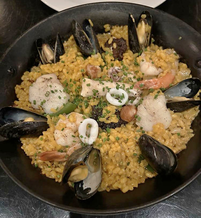 Behold the golden glory of perfectly executed paella, where saffron rice meets fresh seafood in a symphony of Mediterranean flavors.