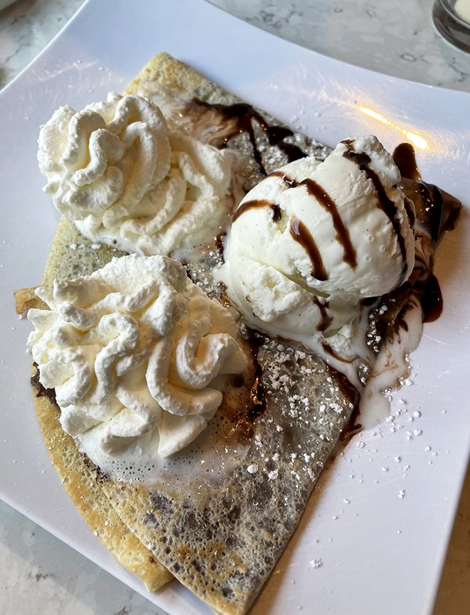 Nutella Crepe with Vanilla Ice Cream: The holy trinity of desserts &ndash; warm Nutella-filled crepe, cool vanilla ice cream, and pillowy whipped cream creating a textural masterpiece.