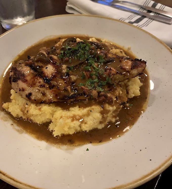 Chicken Marsala perfection: tender meat bathed in rich wine sauce over creamy polenta that'll haunt your dreams.