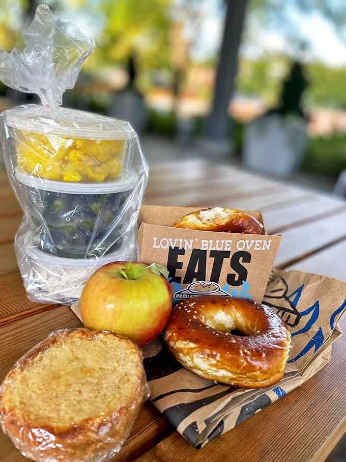 The ultimate picnic spread – fresh fruit, golden pastries, and that signature brown bag announcing you've scored the good stuff.