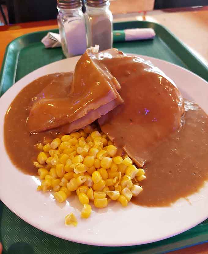 Tender roast beef drowning in gravy alongside corn creates a plate of pure comfort food magic.