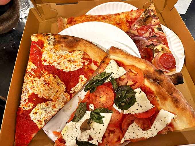 Pizza perfection on a paper plate &ndash; the Caprese slice showcases fresh mozzarella, tomatoes, and basil that would make an Italian grandmother weep with joy.