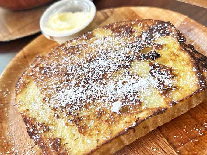 Golden-brown French toast dusted with powdered sugar sits ready to satisfy your AM sweet tooth, no judgment here.