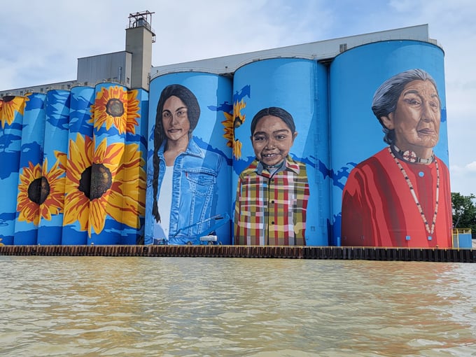 Towering portraits celebrate indigenous heritage alongside golden sunflowers, creating a visual symphony that can be spotted from miles away.