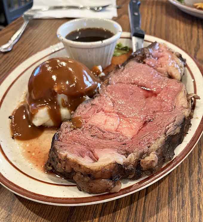 The prime rib arrives as a thick, perfectly cooked slab of beef with au jus, looking like something Fred Flintstone would order.