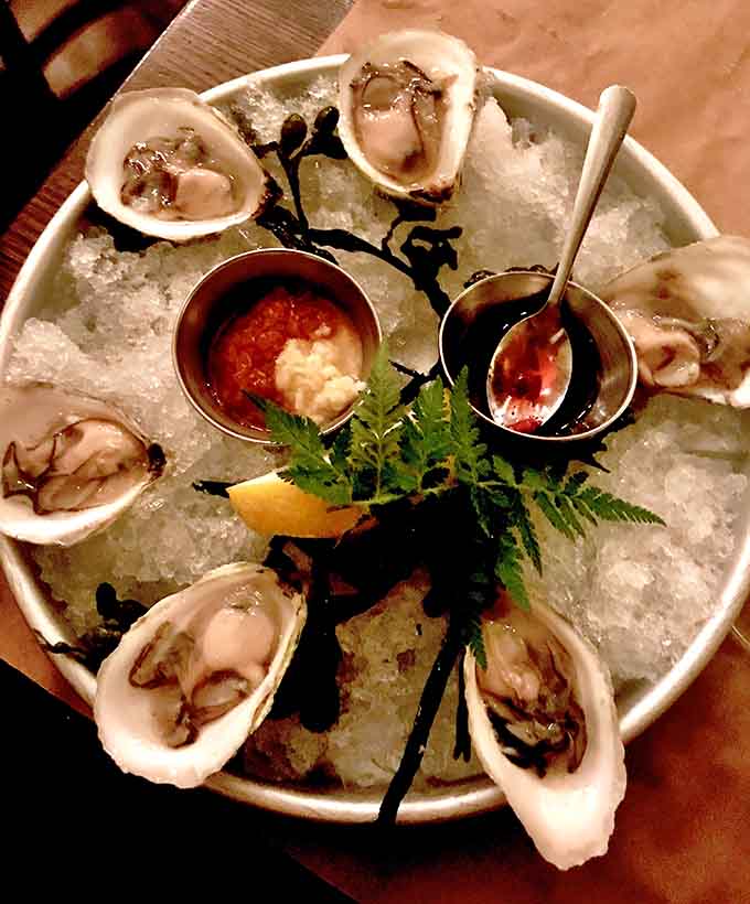 Fresh oysters on ice, looking like they just decided to attend their own delicious party.