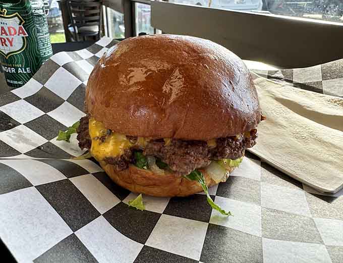 Behold the cheeseburger in its natural habitat, perfectly toasted bun cradling a juicy patty under a blanket of melted cheese.