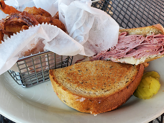 The French Dip arrives with tender roast beef nestled in a soft roll, accompanied by a bowl of savory au jus that's practically begging for a good dunk.