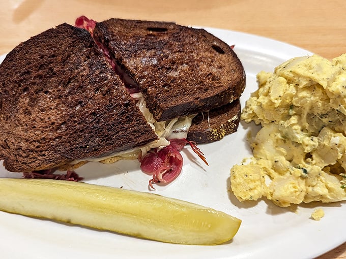 A classic Reuben on dark rye with potato salad &ndash; architecture you can eat, where each layer contributes to a symphony of deliciousness.