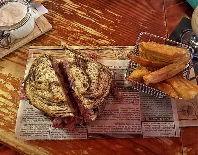 This isn't just a sandwich; it's a towering Reuben masterpiece with layers of corned beef nestled between grilled rye, accompanied by golden chips.
