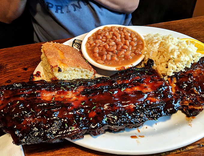 These glistening ribs, accompanied by cornbread and beans, look like they've been blessed by the BBQ gods themselves.