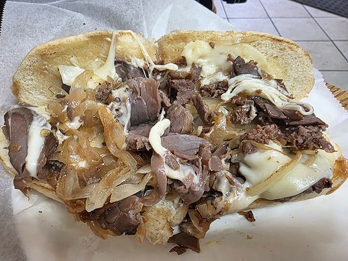 Behold the roast beef masterpiece &ndash; thinly sliced, perfectly seasoned meat cascading with melted cheese and caramelized onions. Poetry between bread.