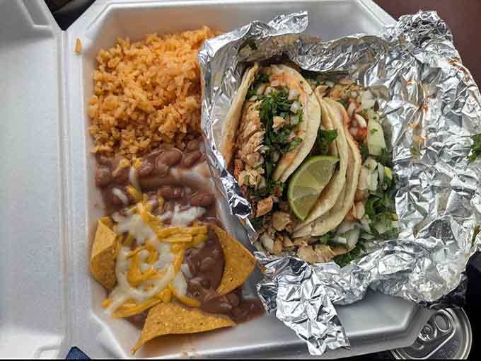 The complete meal experience: tacos, rice, beans, and chips creating a symphony of flavors on one plate.