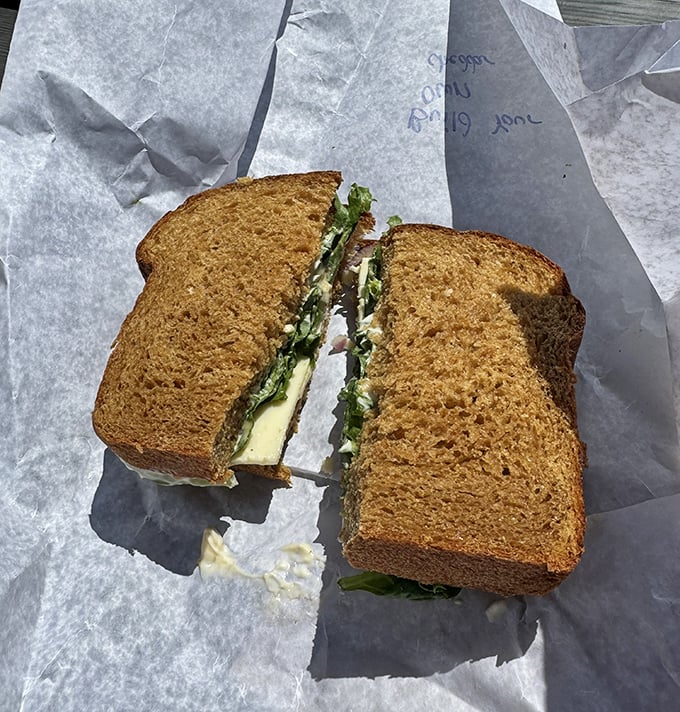 A perfect sandwich cross-section reveals the architecture of flavor &ndash; layers of ingredients nestled between hearty wheat bread, ready for that first magnificent bite.