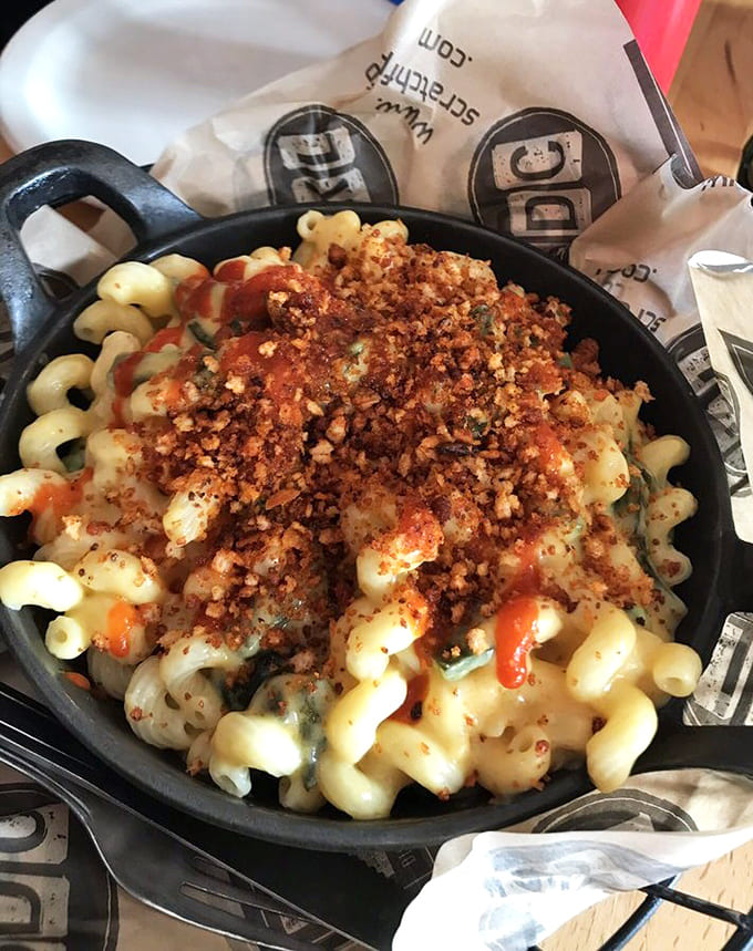 Behold the Fire Mac 'n Cheese in all its glory, served in a cast iron skillet because regular bowls couldn't handle this level of deliciousness.