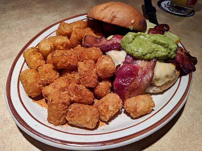 Golden, crispy tater tots piled high alongside a loaded burger prove that sometimes the side dish steals the show completely.