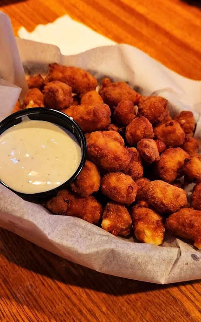 Golden, crispy cheese curds that squeak with freshness and stretch with every bite, pure Wisconsin magic on a plate.