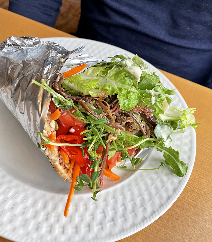 This isn't just any wrap &ndash; it's a colorful explosion of fresh vegetables, creamy hummus, and tangy pickled treats, all embraced by a perfect pita.