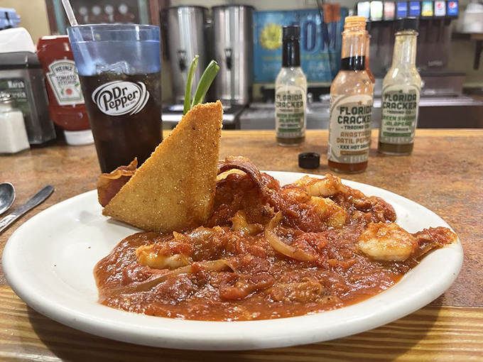 Shrimp and grits that'll make you weak in the knees. Those perfectly cooked crustaceans swimming in tomato sauce alongside a crispy cornbread triangle? Pure poetry.